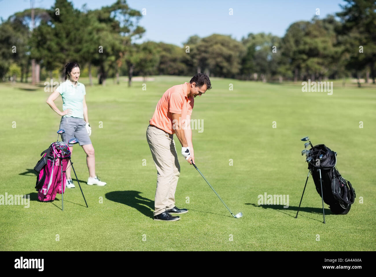 Side view of golfer taking shot Stock Photo - Alamy