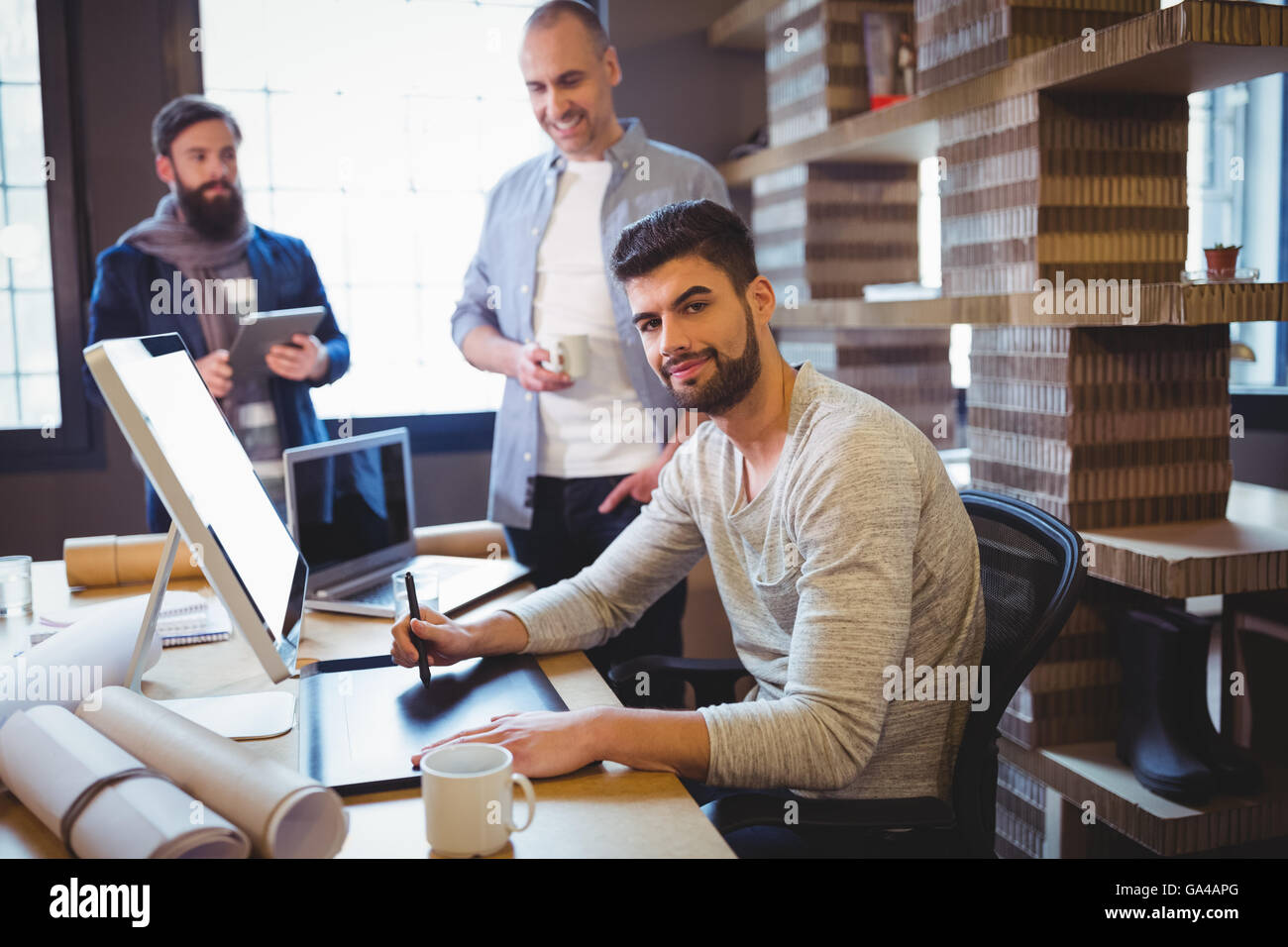 Creative businessman using graphic tablet at computer desk Stock Photo ...