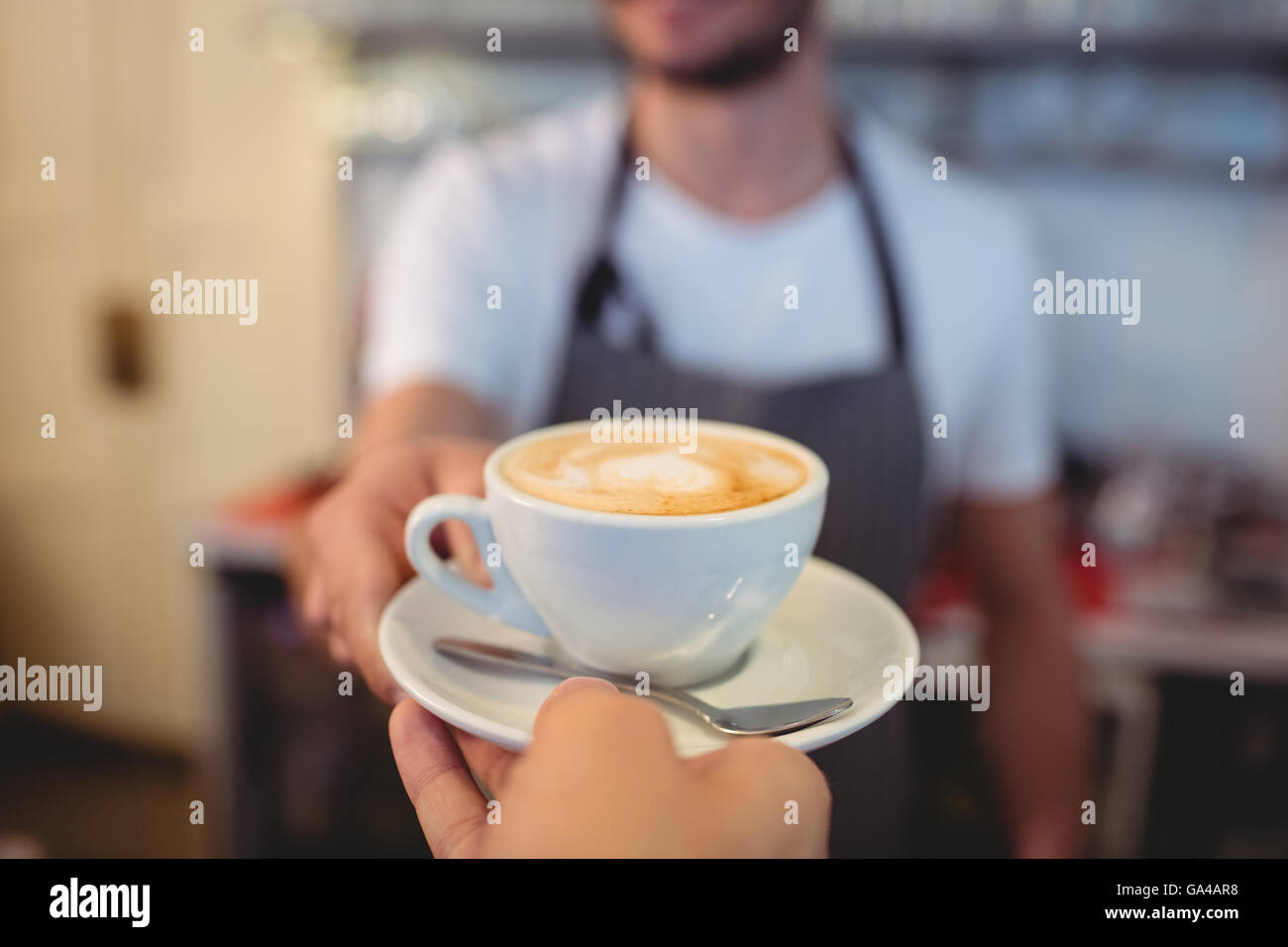 Cropped image of customer taking coffee from waiter at cafe Stock Photo ...