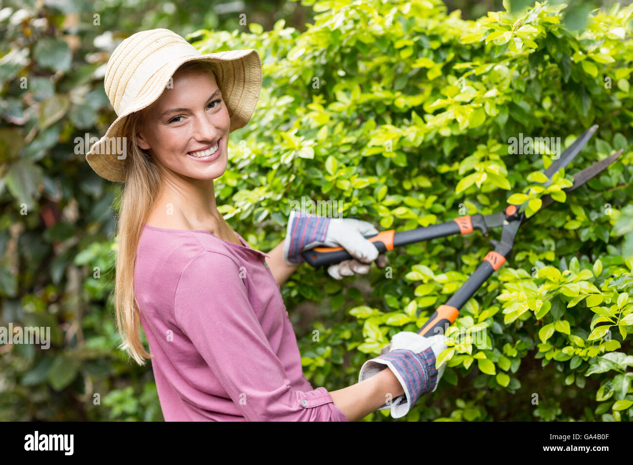 Happy female gardener pruning with clippers Stock Photo - Alamy