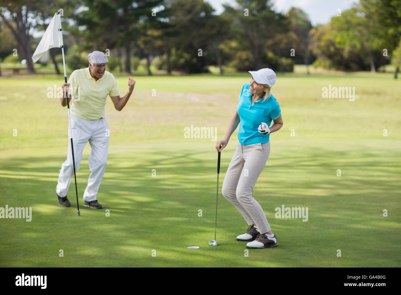 Mature golfer couple celebrating success Stock Photo - Alamy