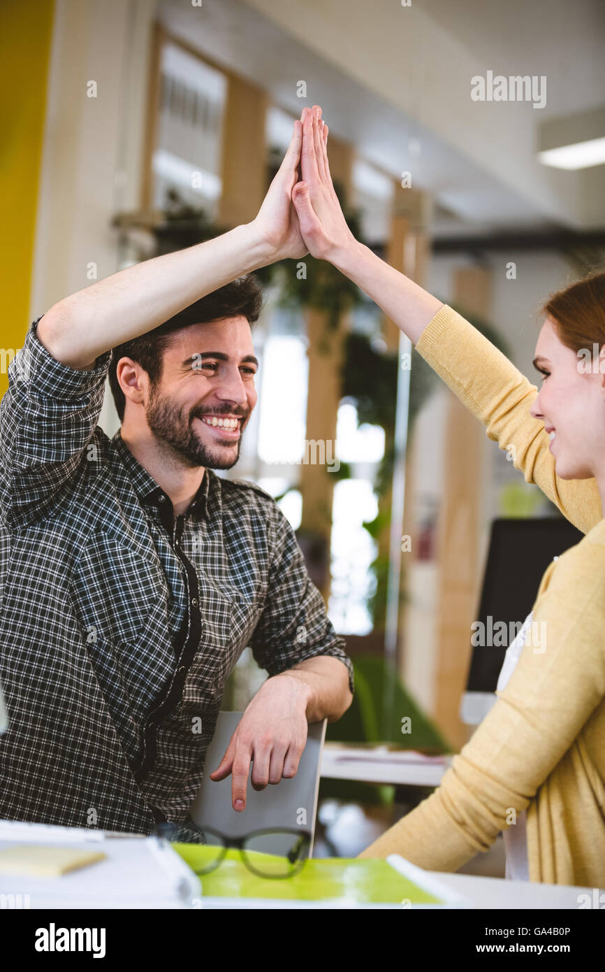 Colleagues giving high-five Stock Photo - Alamy