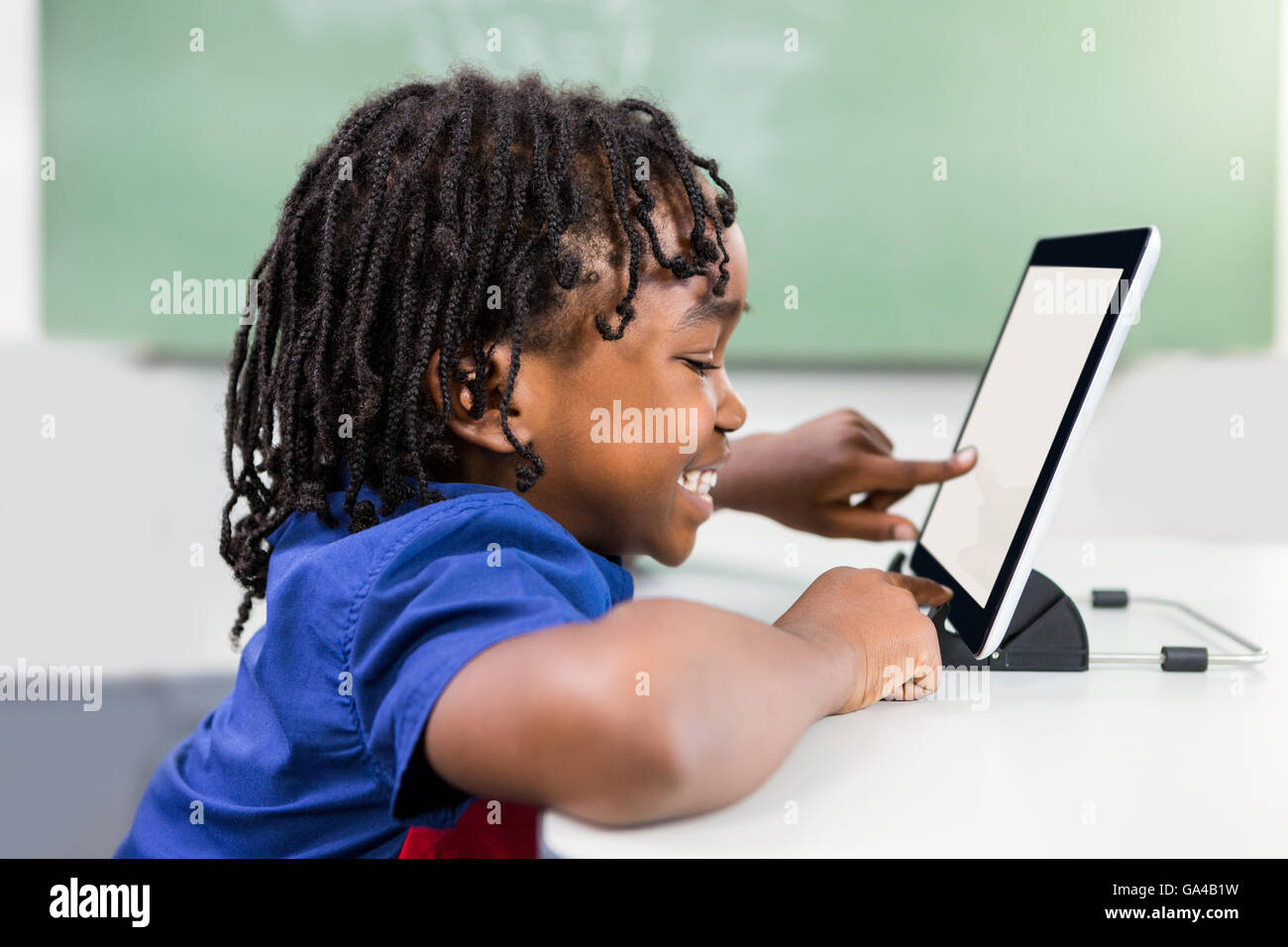 Boy using digital tablet in classroom Stock Photo - Alamy