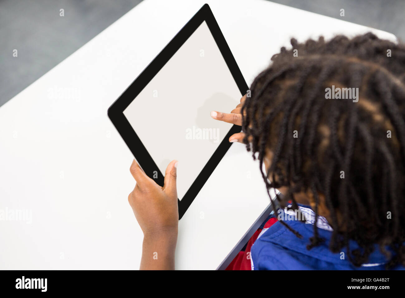 Boy using digital tablet in classroom Stock Photo - Alamy