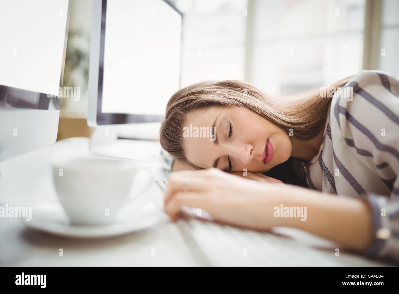 Tired businesswoman taking nap in creative office Stock Photo - Alamy