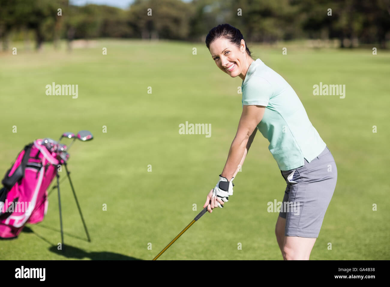 Side view of cheerful woman playing golf Stock Photo - Alamy