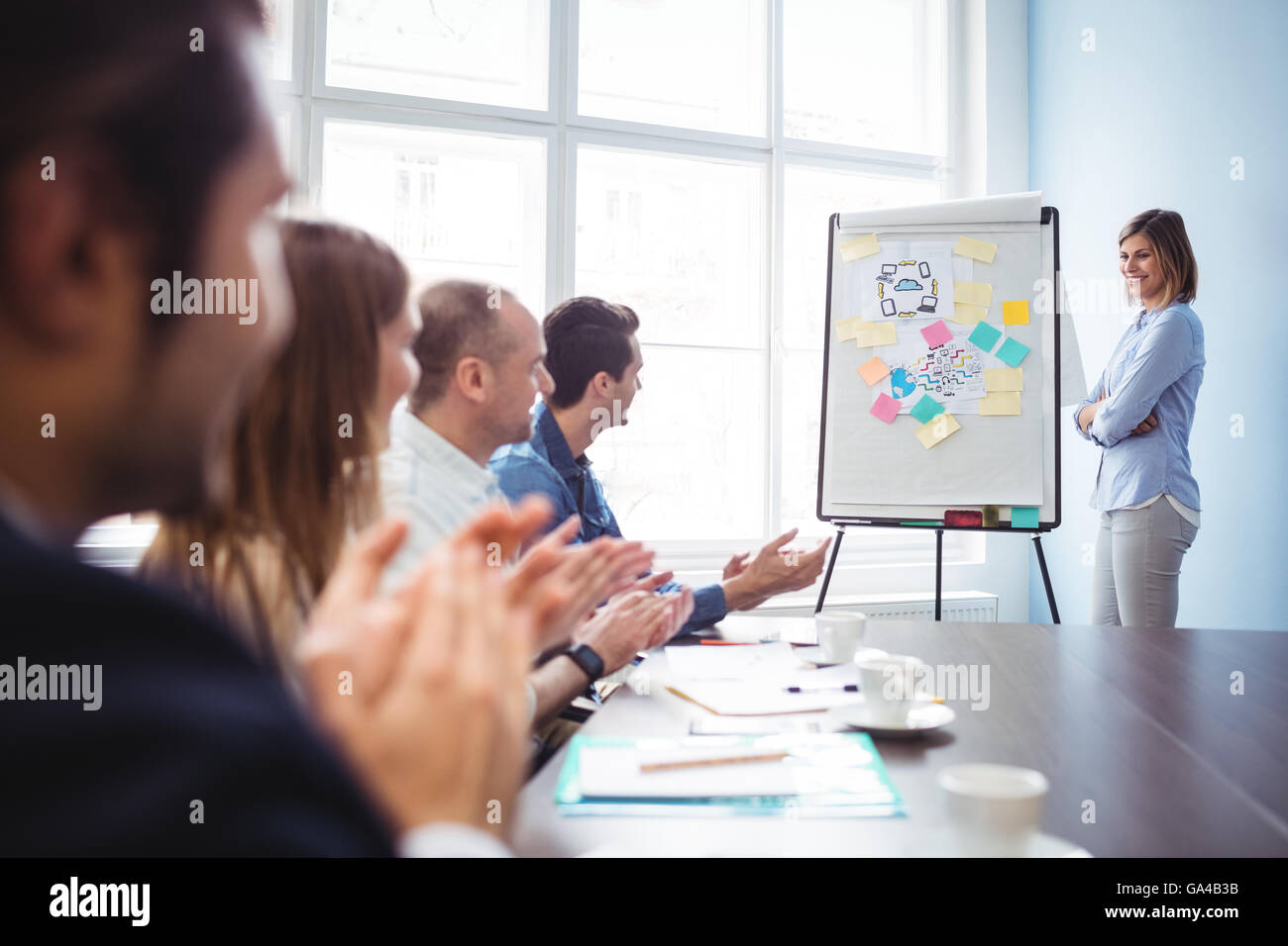 Coworkers clapping for businesswoman Stock Photo - Alamy