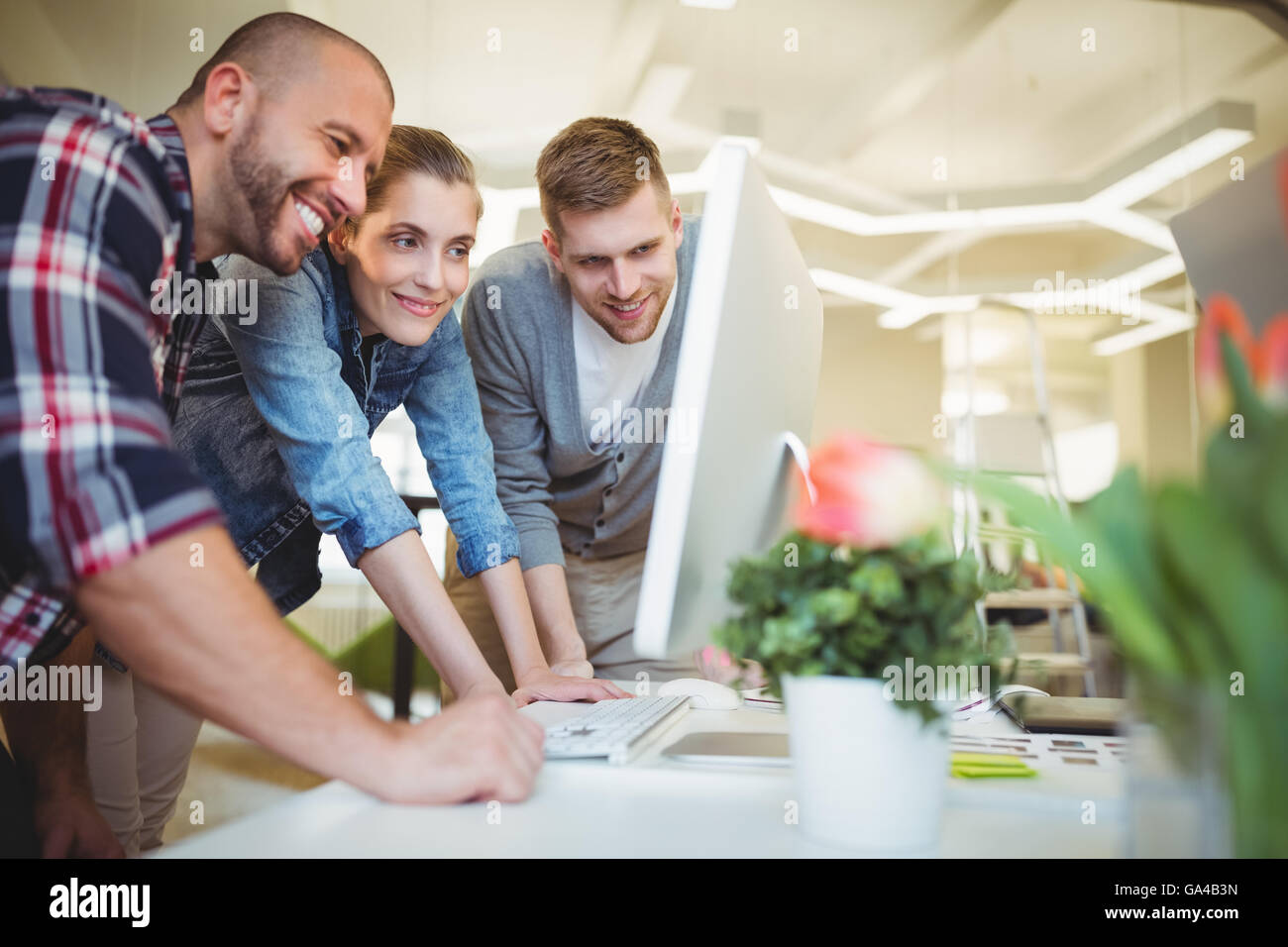 Business people looking at computer in office Stock Photo - Alamy