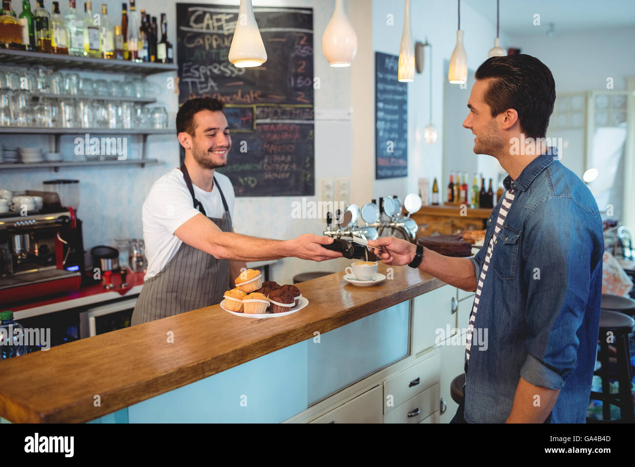Happy customer paying through credit card at coffee shop Stock Photo ...