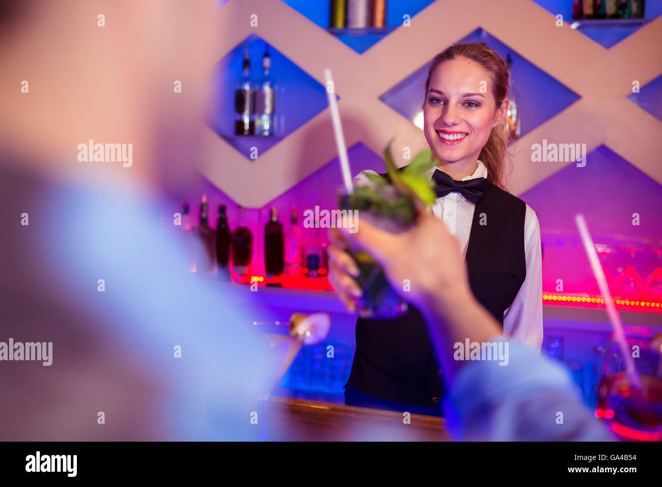 Young barmaid serving drink to male costumer Stock Photo - Alamy