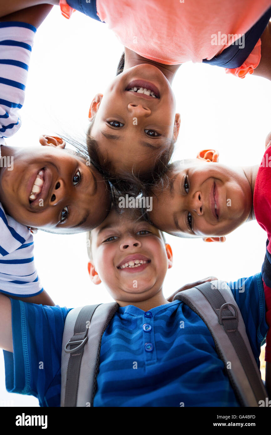 Portrait of smiling children forming huddle Stock Photo - Alamy