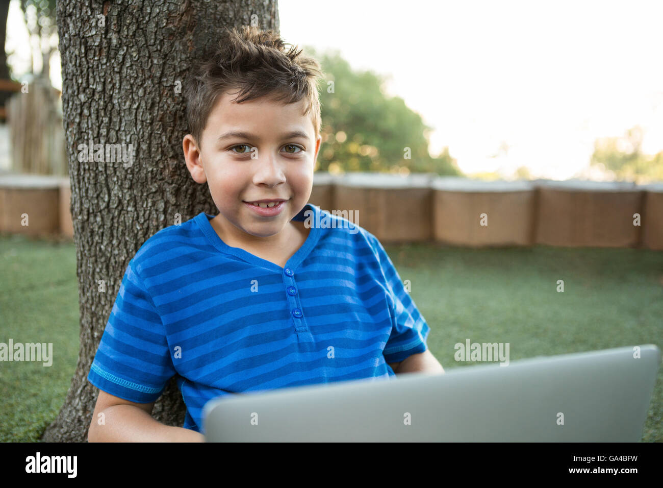 Portrait of boy using laptop at park Stock Photo - Alamy