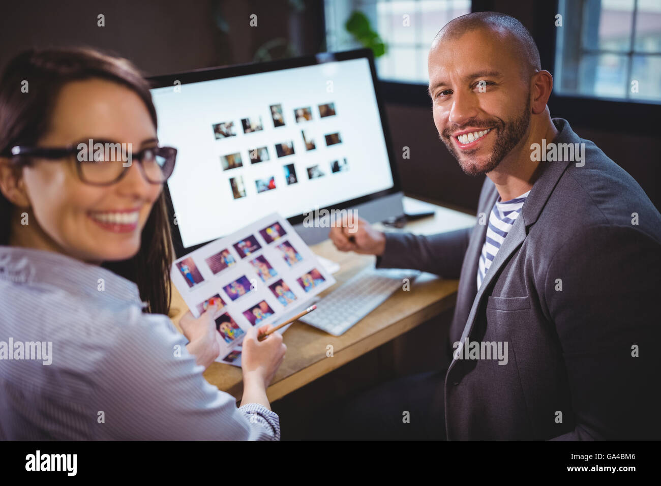 Coworkers sitting at computer desk in creative office Stock Photo - Alamy