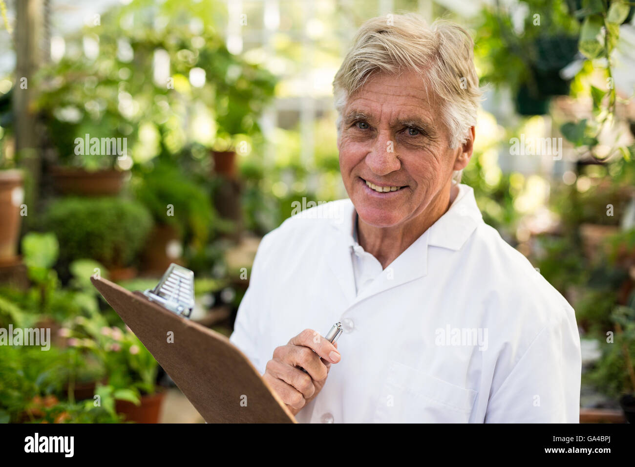 Confident senior male scientist holding clipboard Stock Photo - Alamy