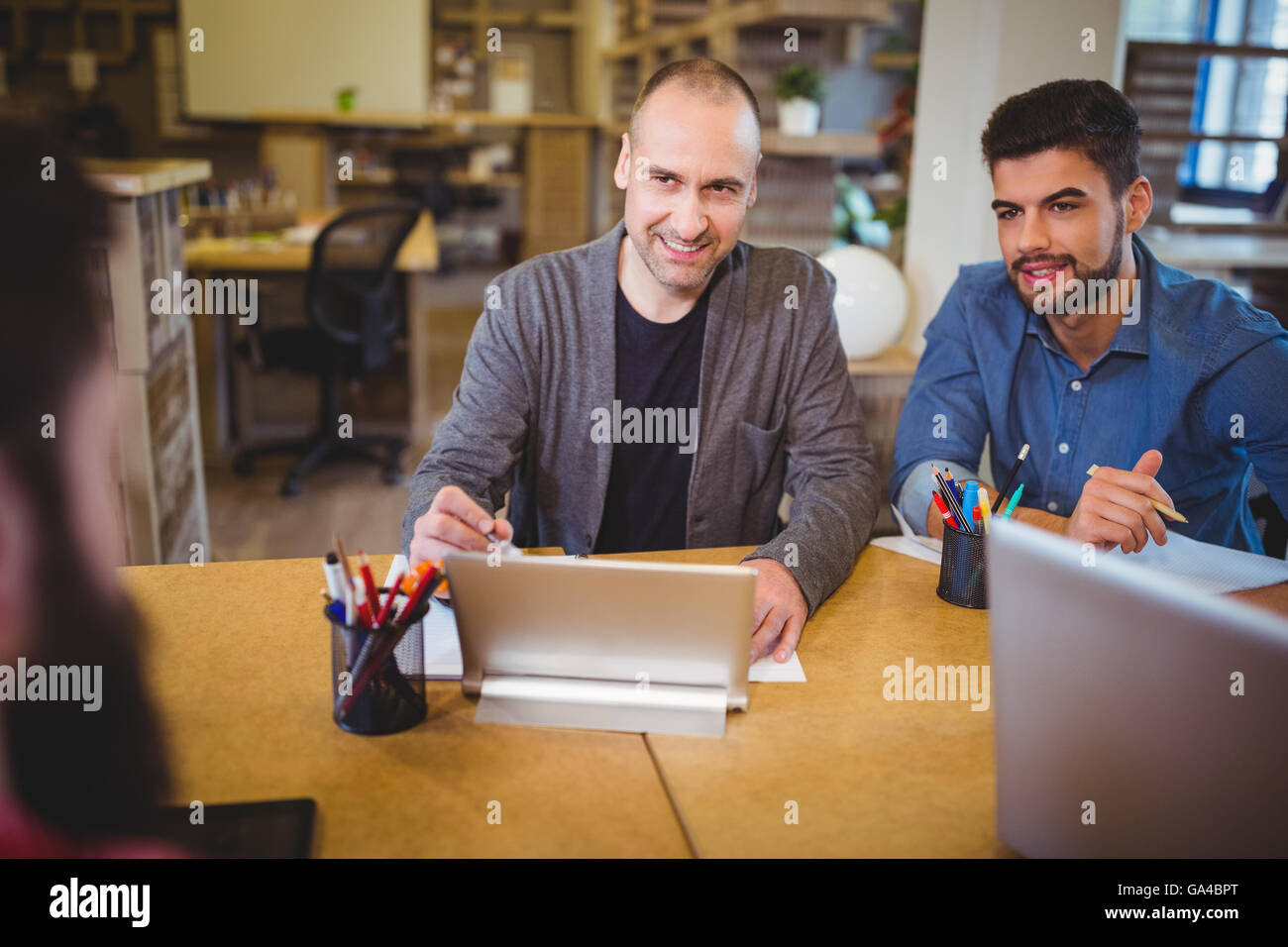Business people smiling while talking at desk Stock Photo - Alamy