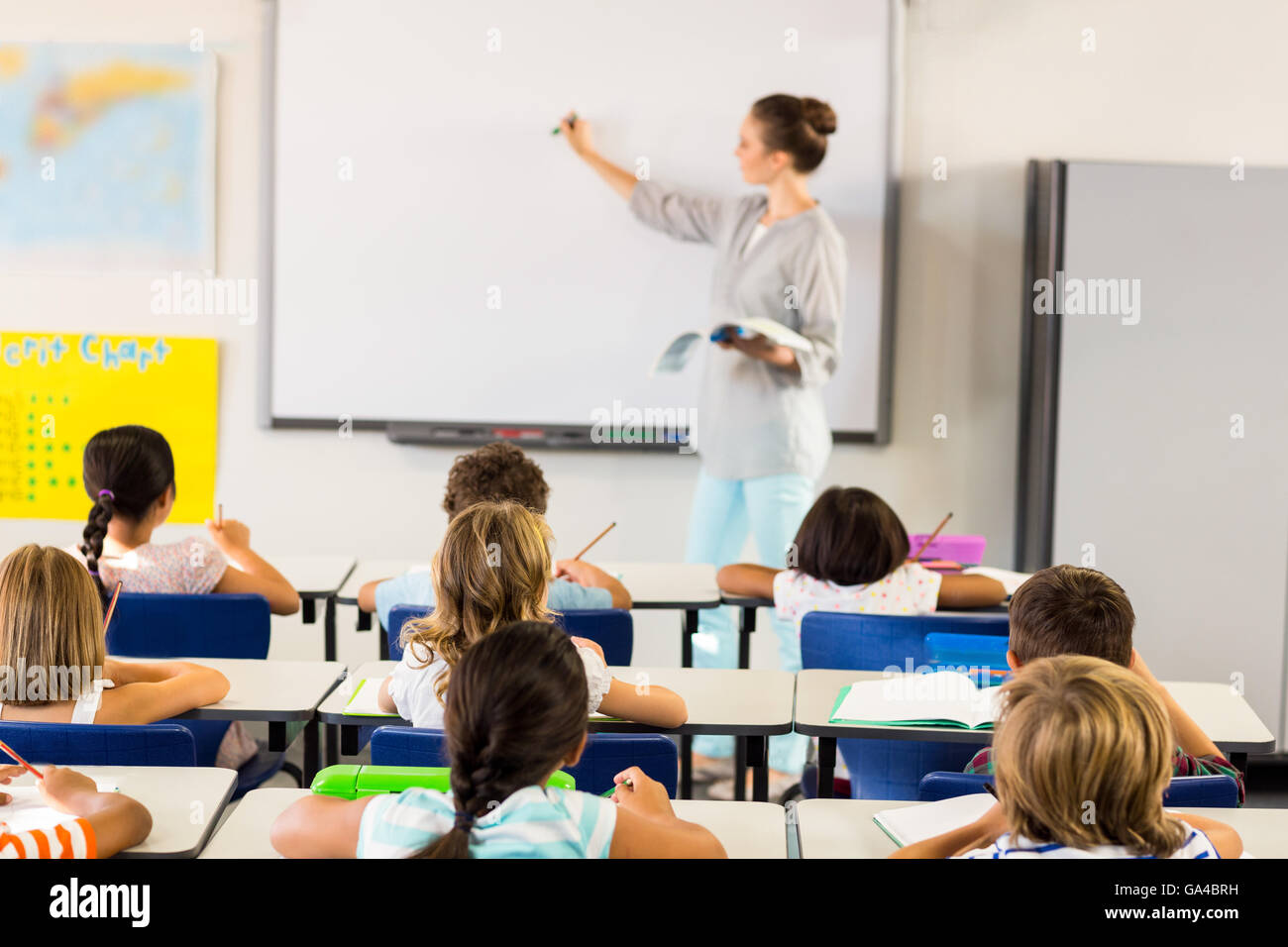Teacher teaching schoolchildren Stock Photo - Alamy
