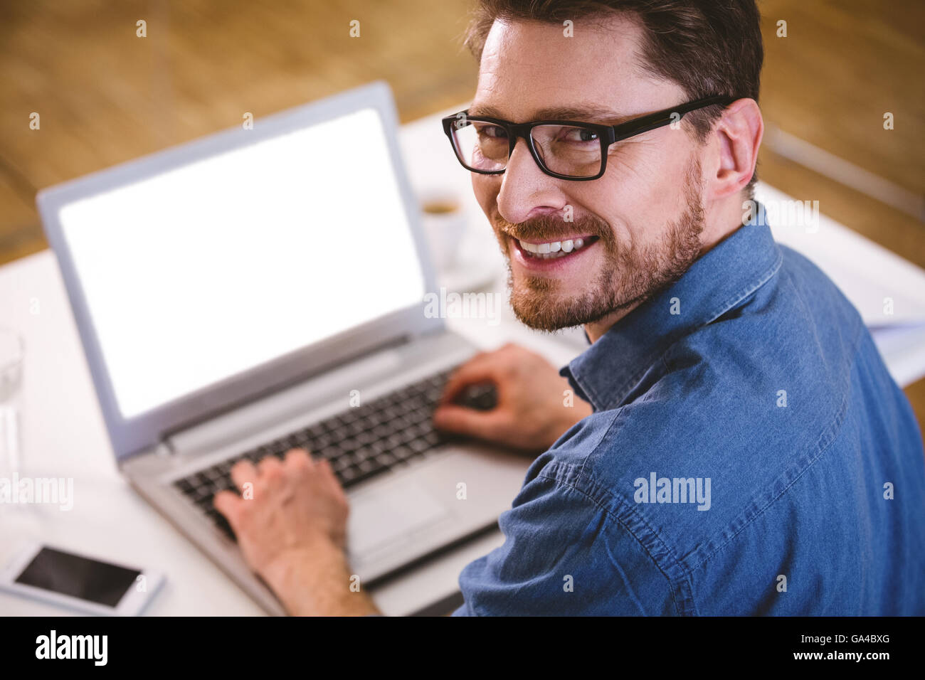 Portrait of confident executive looking over shoulder at creative ...