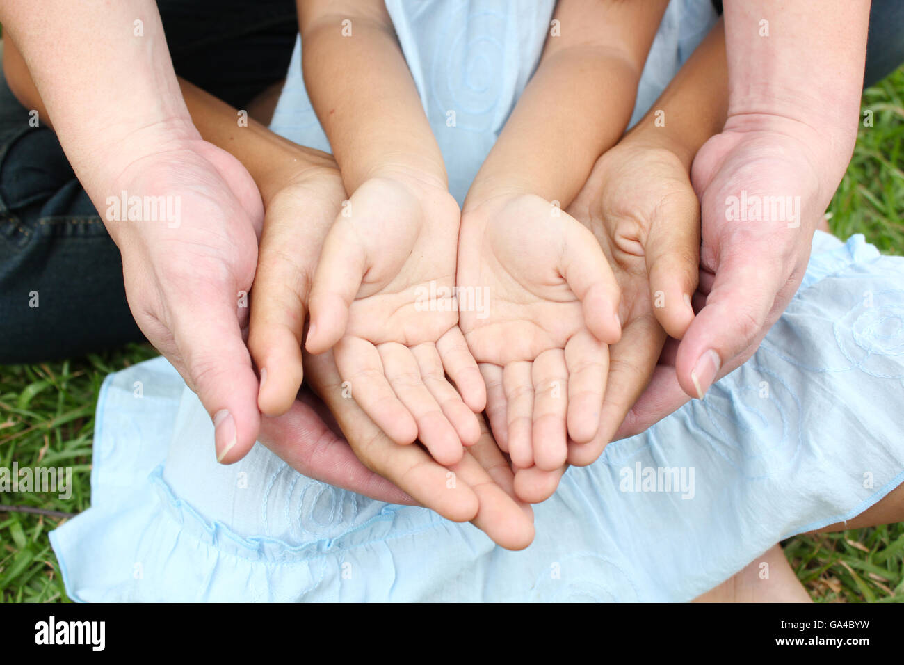 Adult hands holding kid hands in the park Stock Photo - Alamy