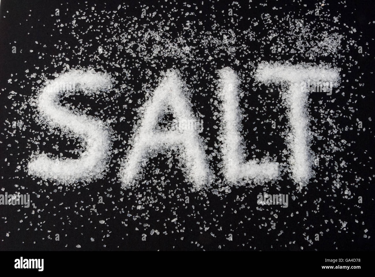 Coarse-grained sea salt with the word SALT on black background Stock ...