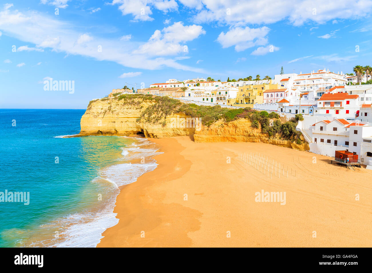 A view of beach with colourful houses in Carvoeiro fishing village ...
