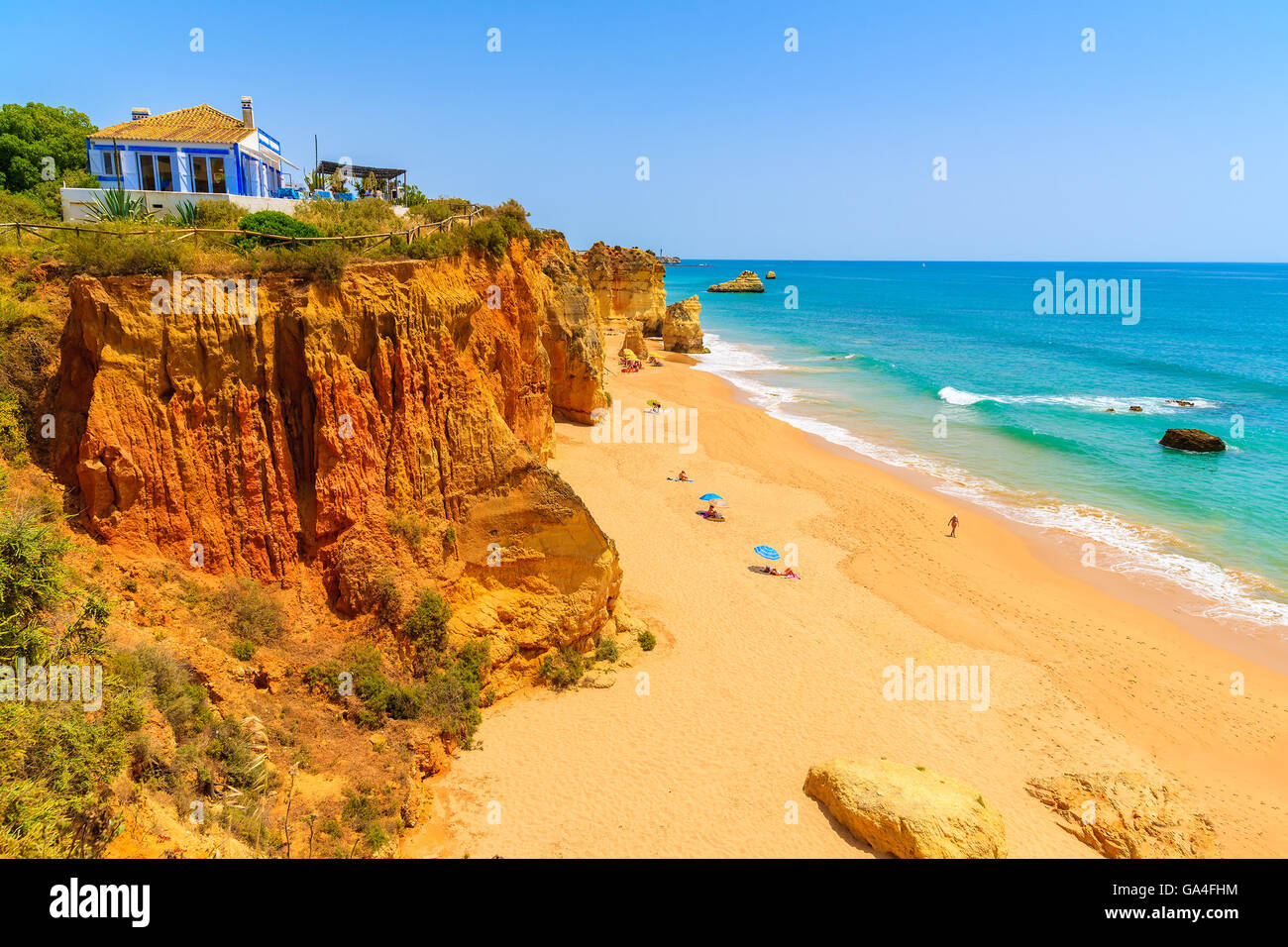 Tourists sunbathing on beautiful Praia da Rocha beach, Algarve region ...