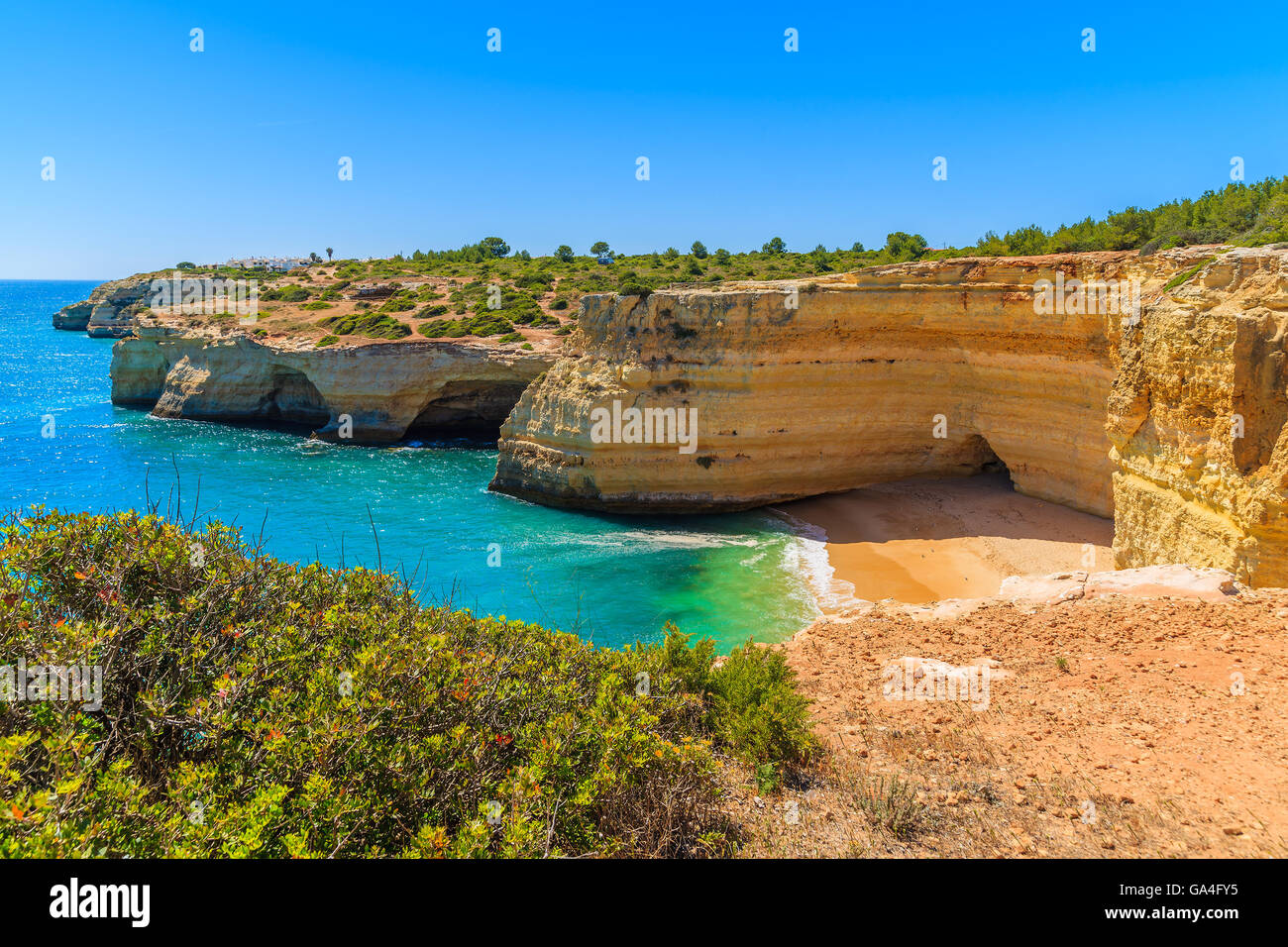 Sandy beach with cliff rocks in small cove near Carvoeiro town, Algarve ...