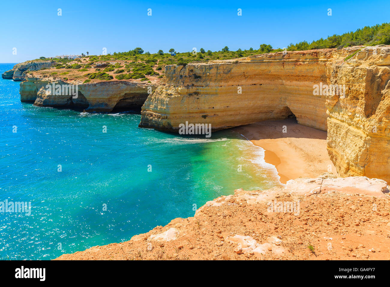 Sandy beach with cliff rocks in small cove near Carvoeiro town, Algarve ...
