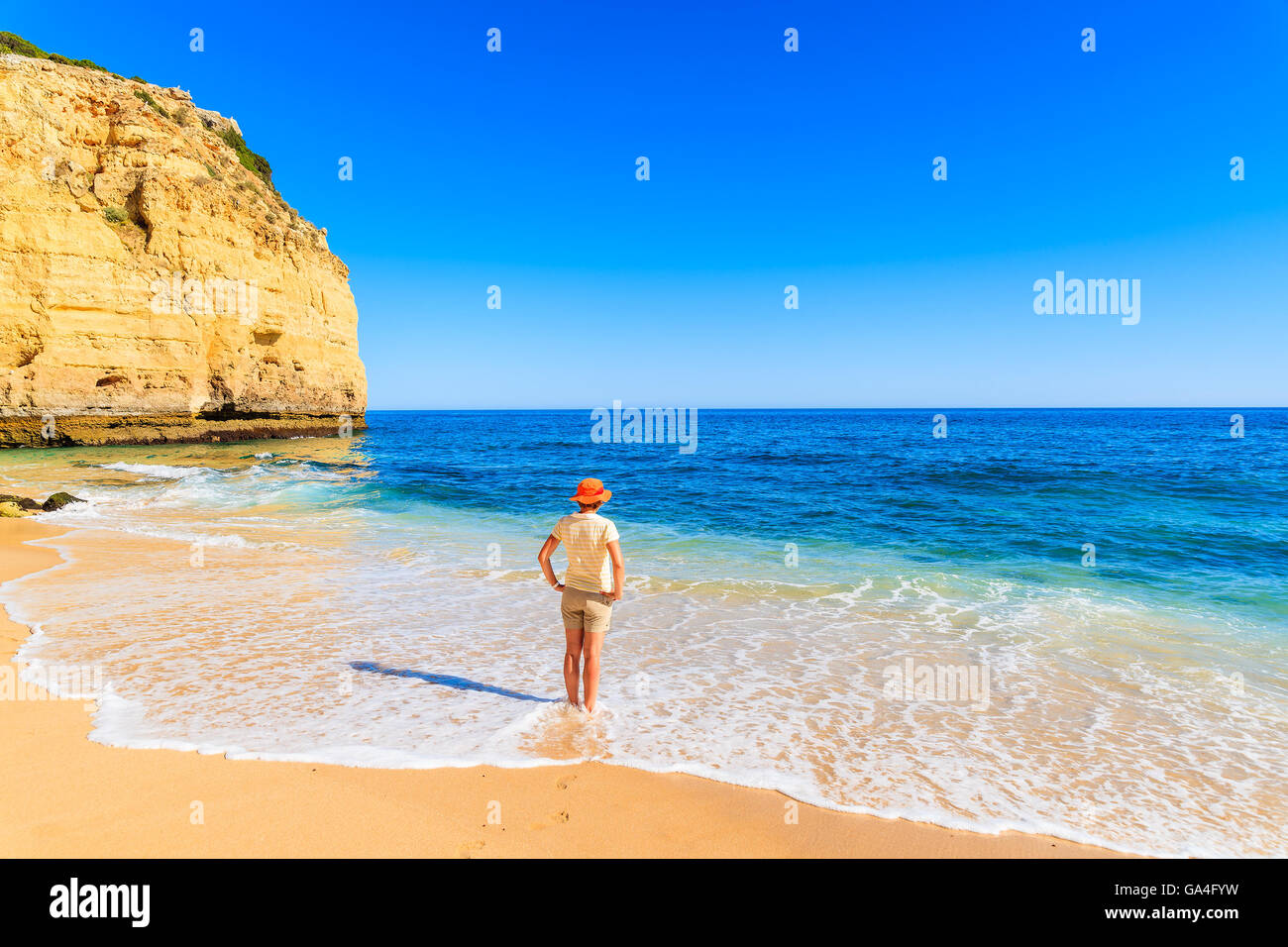 Young woman tourist standing in water of sea wave on Vale Centianes ...