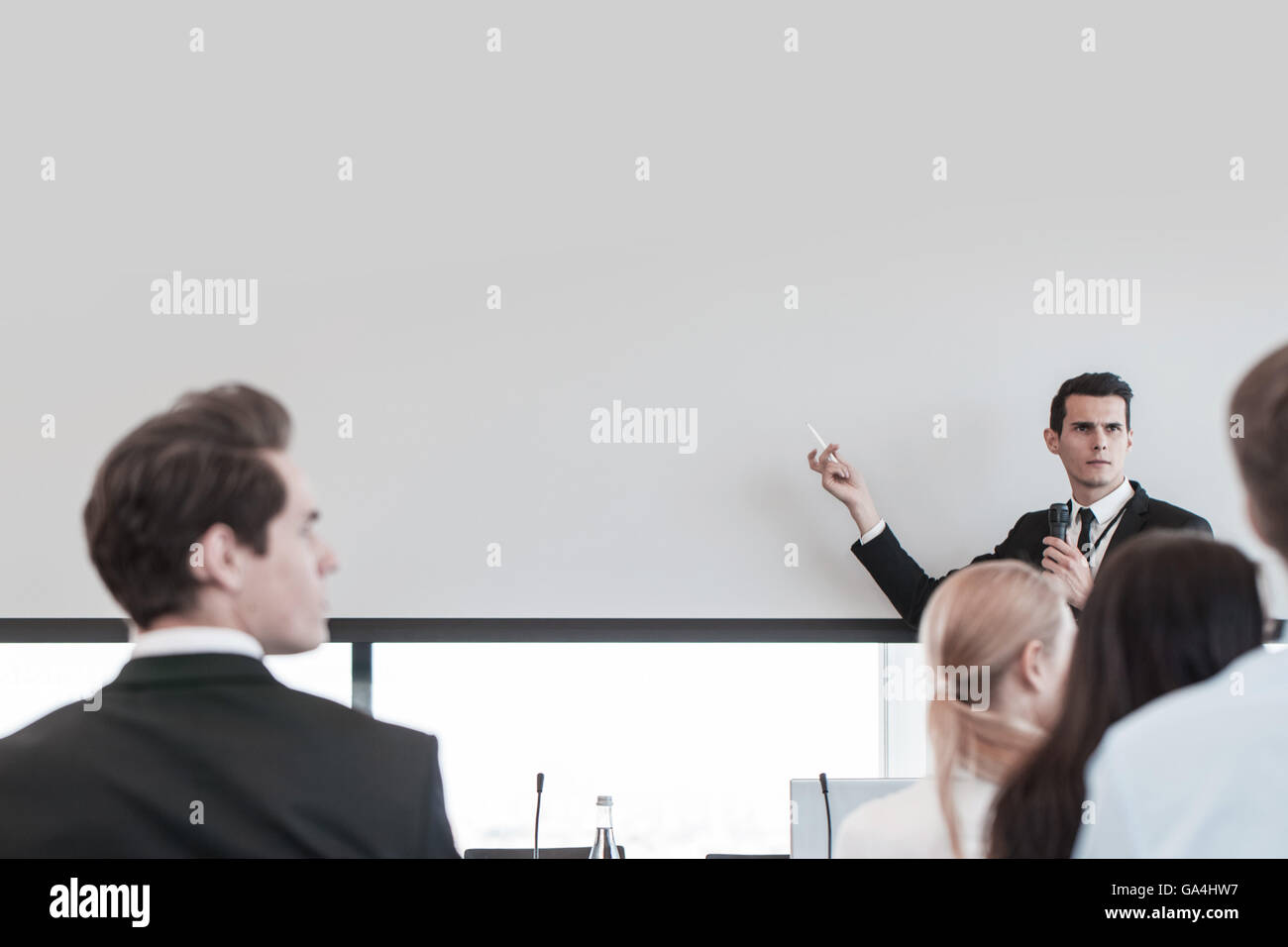 Business man speaking at presentation in microphone in office Stock ...