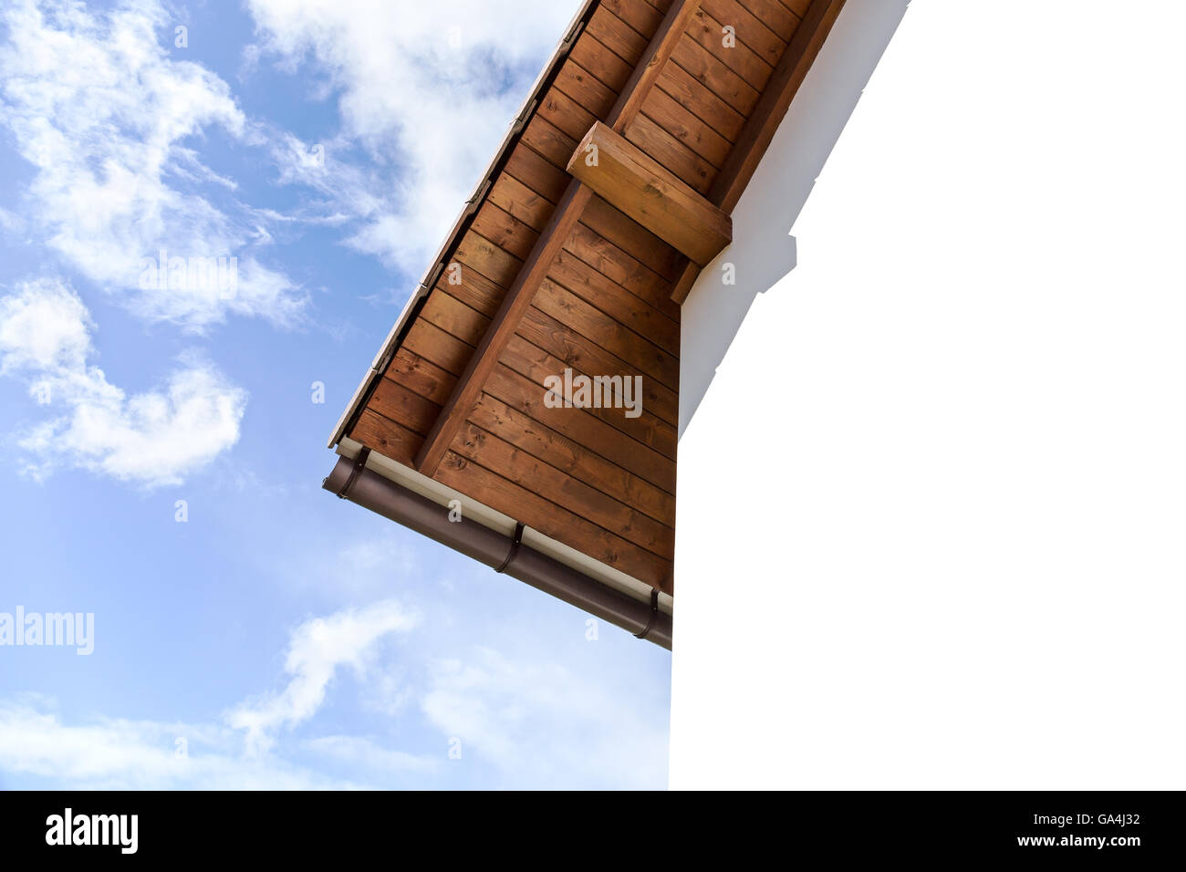 Roof with rafters and plaster wall of house against cloudy sky Stock ...