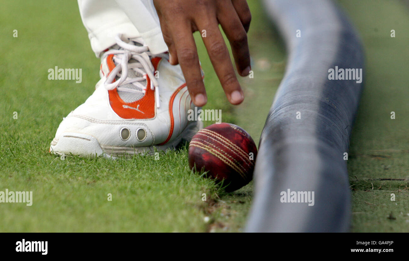 An Indian fielder collects the ball from the edge of the outfield ...