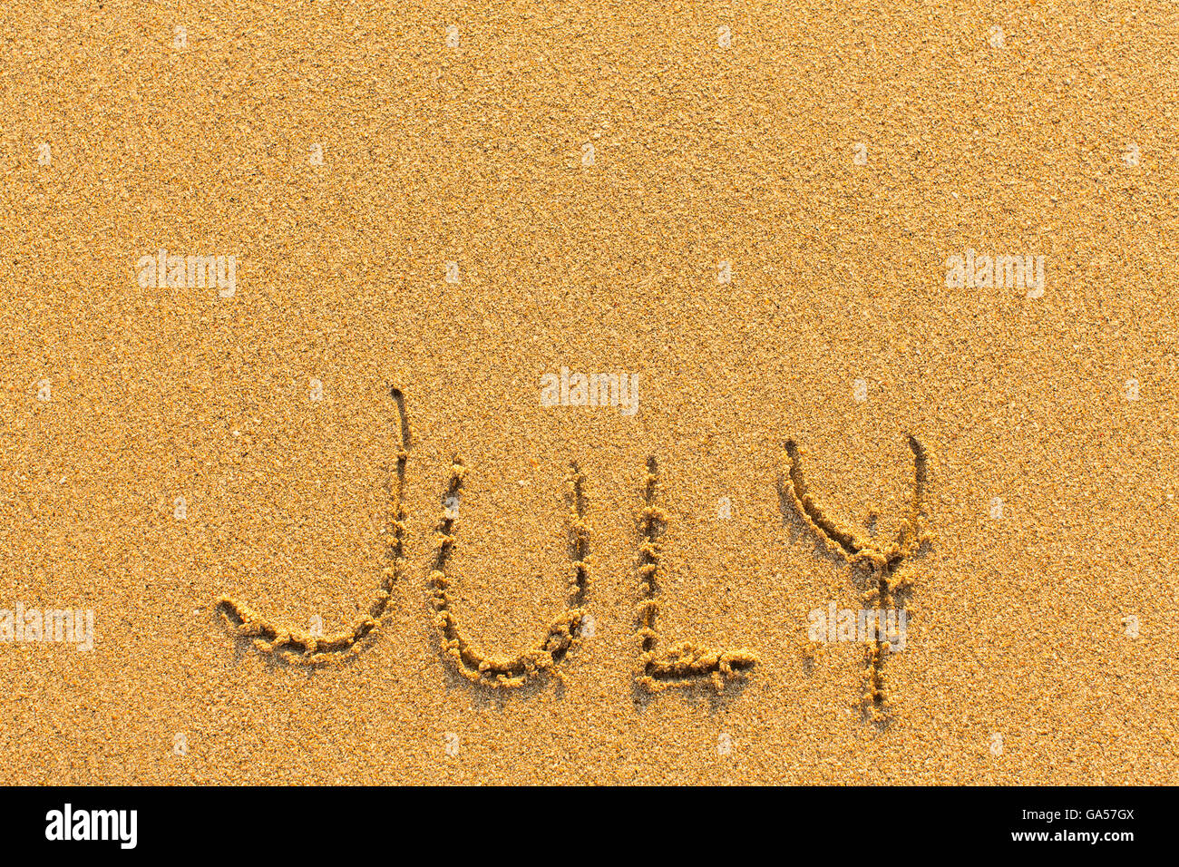 JULY drawn by hand on a golden sandy sea beach Stock Photo - Alamy
