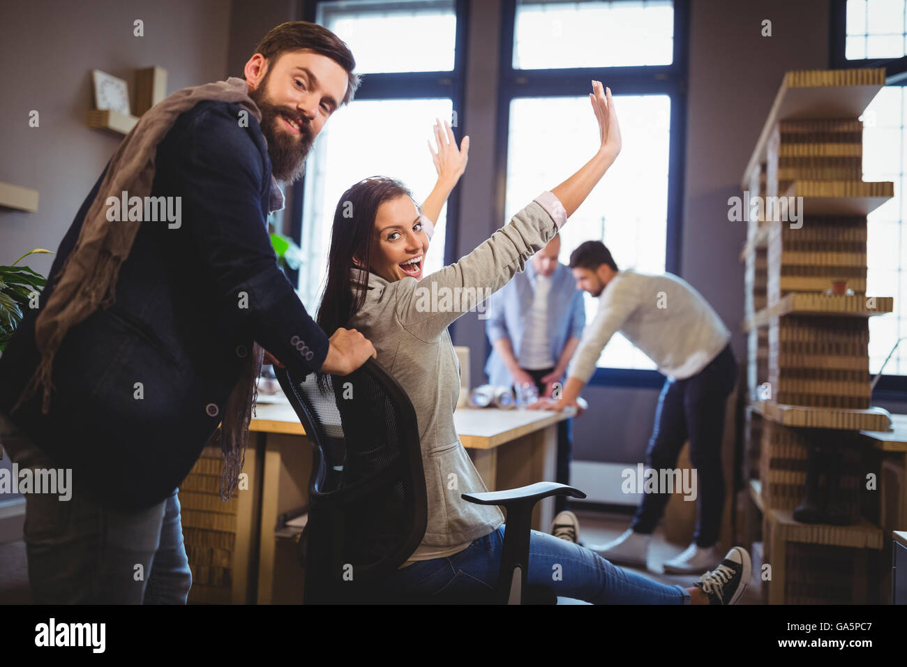 Happy coworkers enjoying by desk in creative office Stock Photo - Alamy