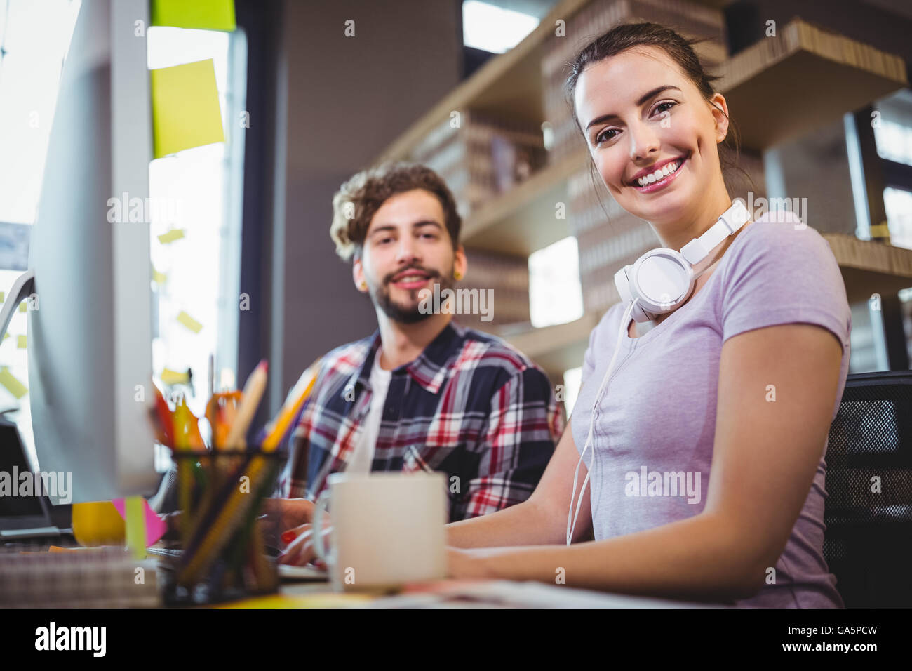 Businesswoman sitting by male coworker at computer desk Stock Photo - Alamy