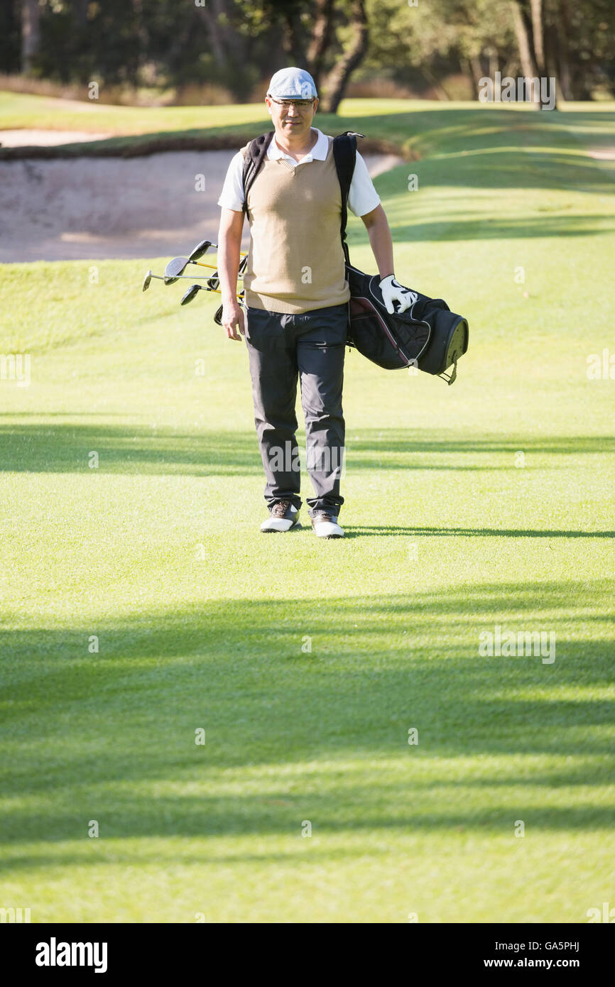 Portrait of sportsman walking with his golf bag Stock Photo - Alamy