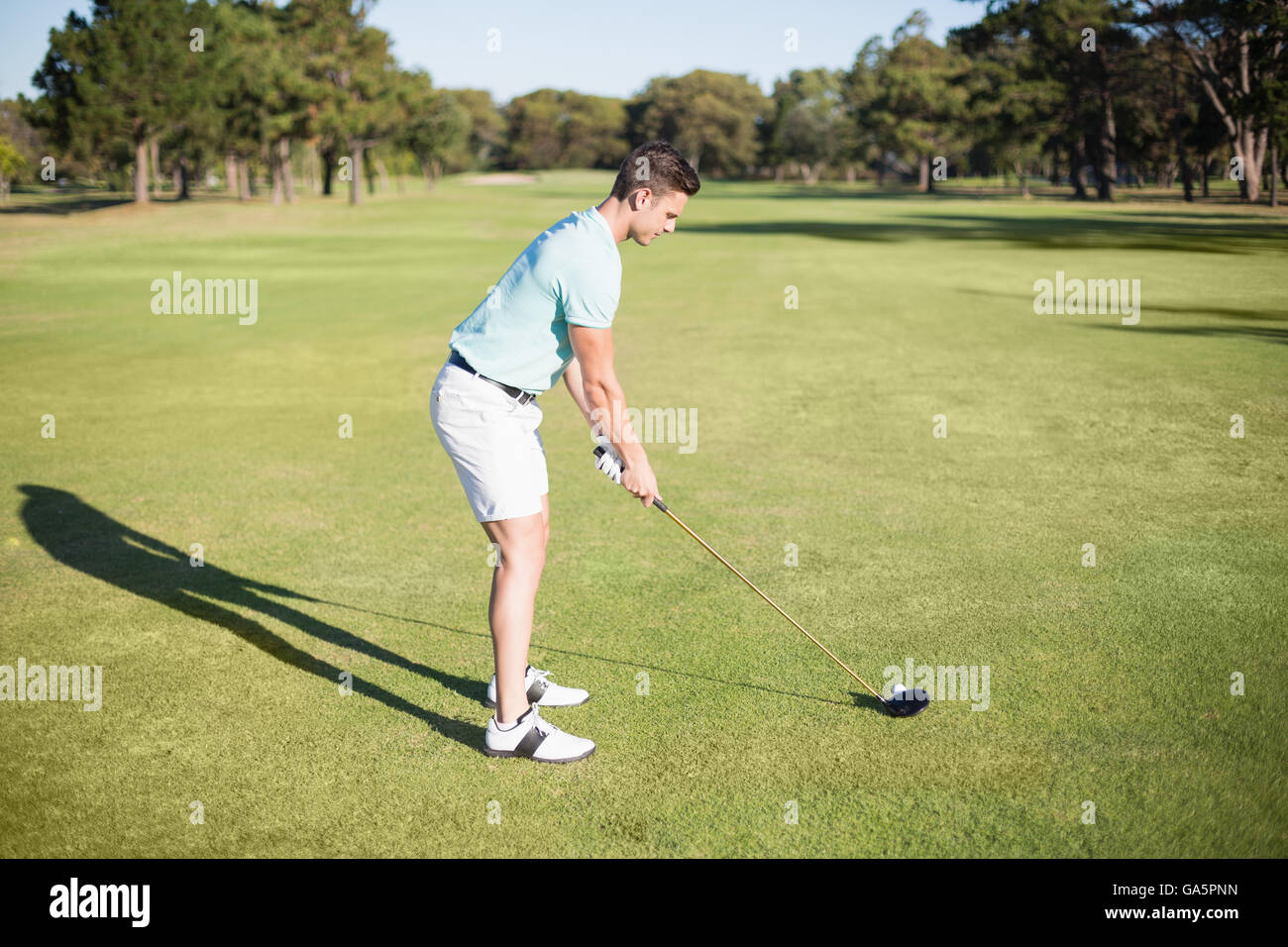 Full length side view of young man playing golf Stock Photo - Alamy