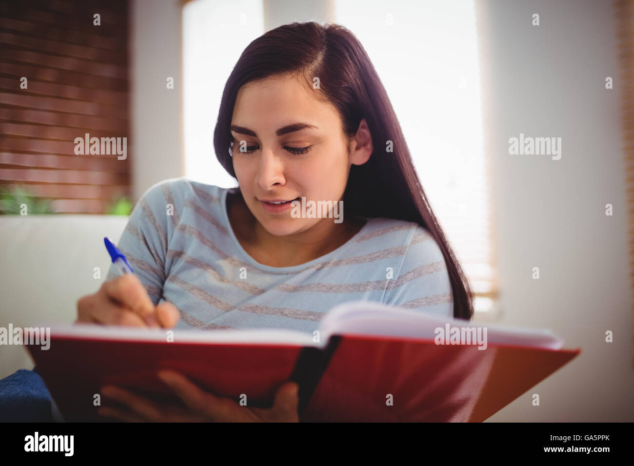 Woman writing on book Stock Photo - Alamy