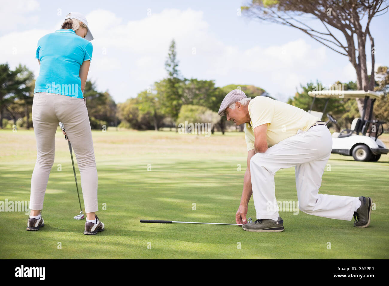 Full length of golfer couple Stock Photo - Alamy