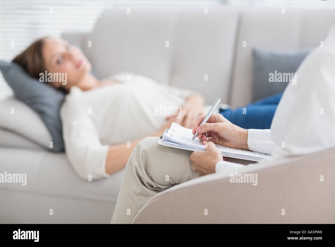 Therapist writing notes of patient Stock Photo - Alamy