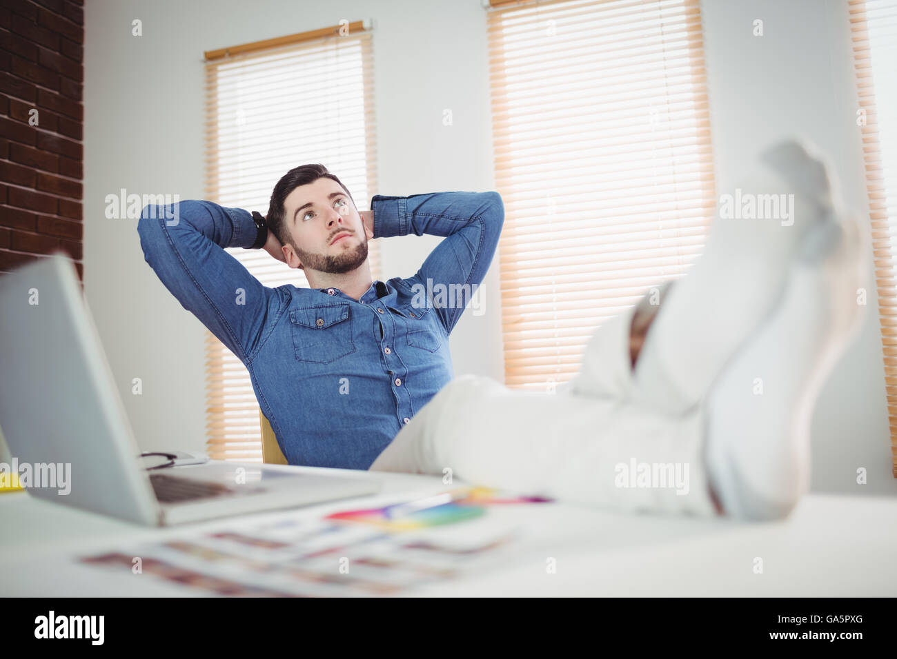 Thoughtful man relaxing in office Stock Photo - Alamy