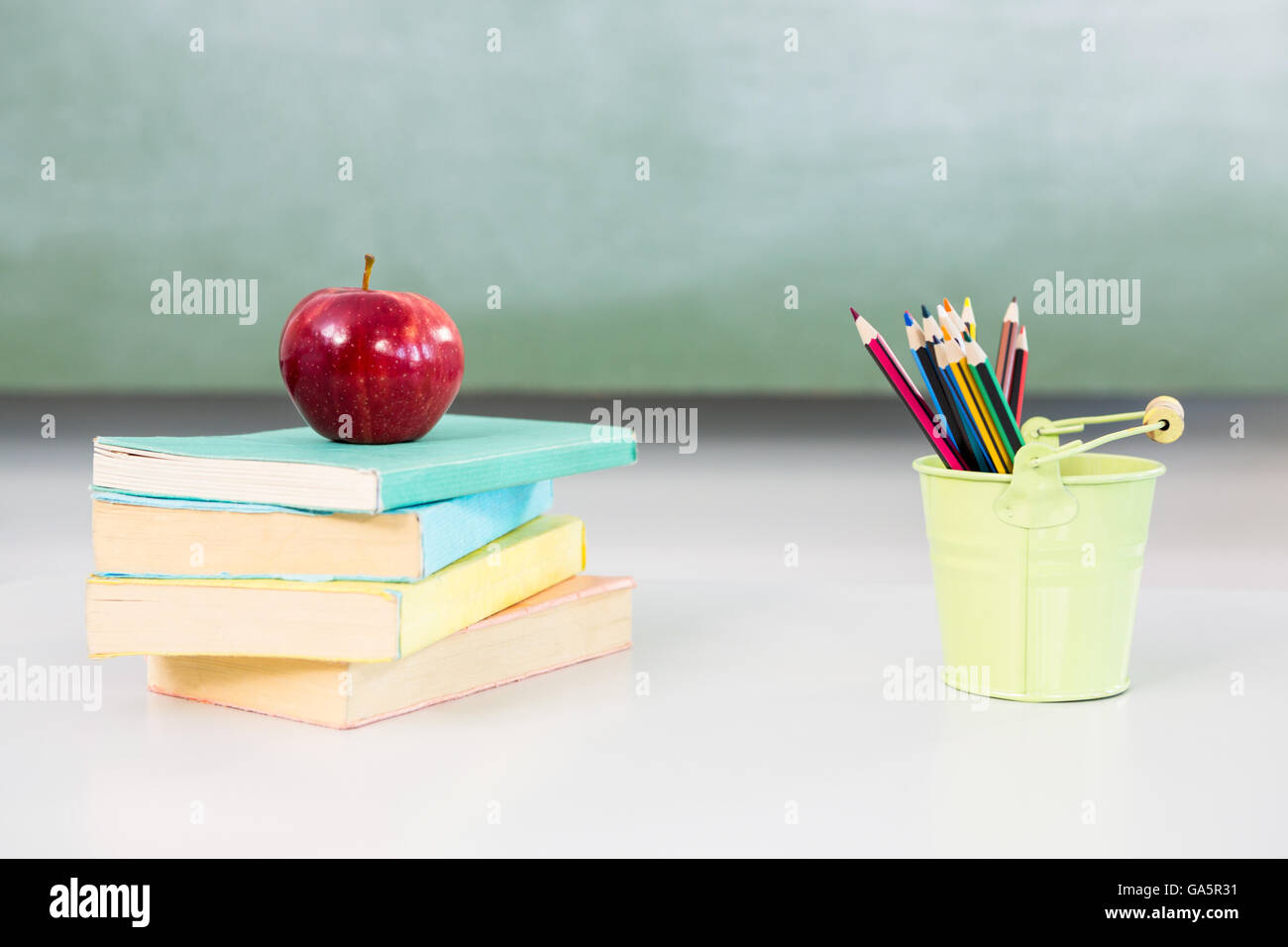 Apple with books and desk organizer on table Stock Photo - Alamy