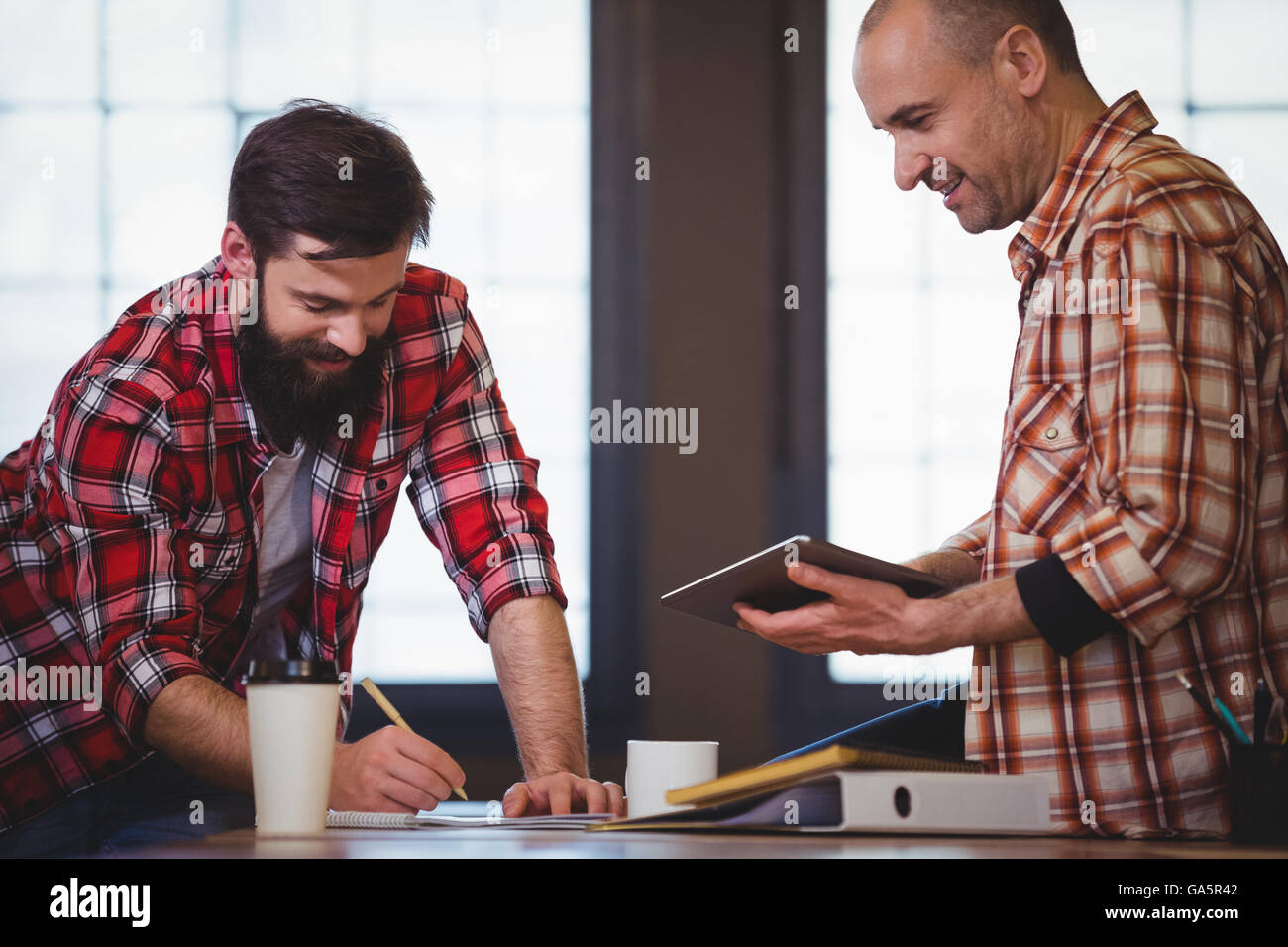 Smiling male colleagues discussing in creative office Stock Photo - Alamy