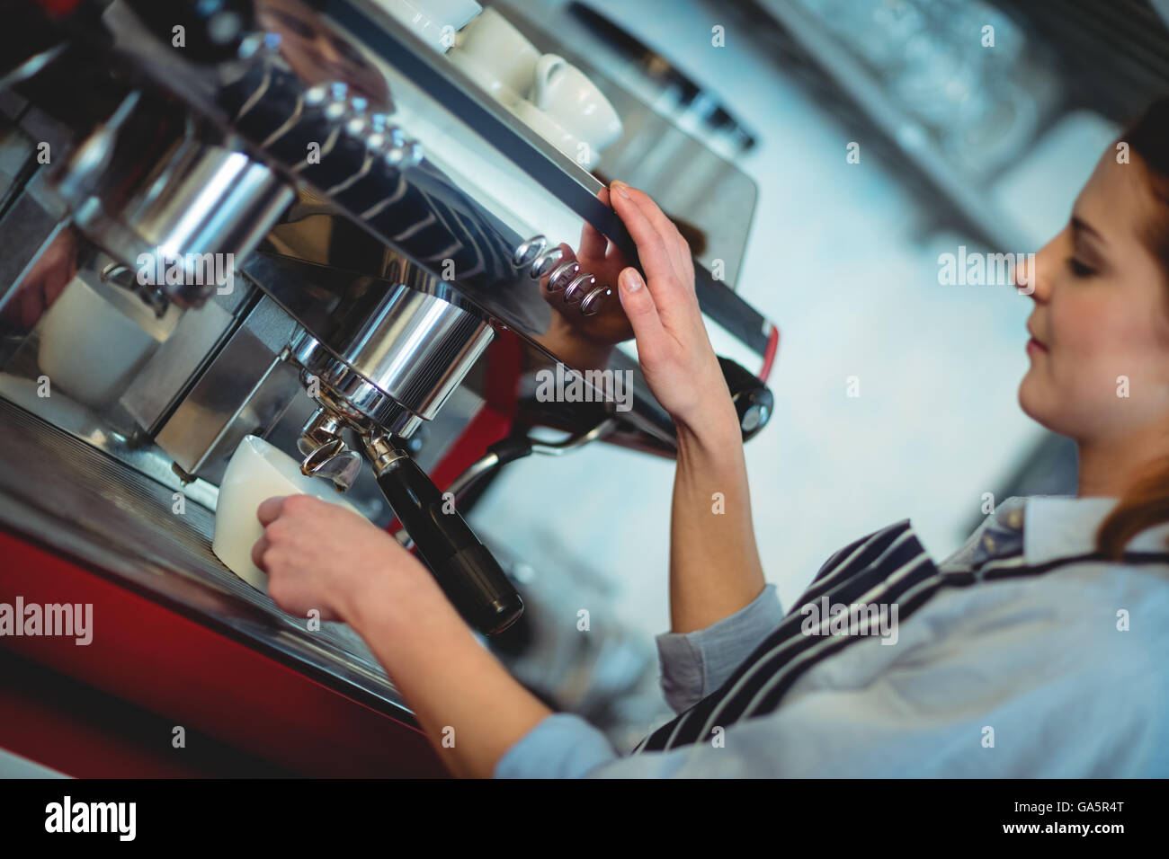 Tilt shot of barista using espresso machine to pour coffee in cup Stock ...