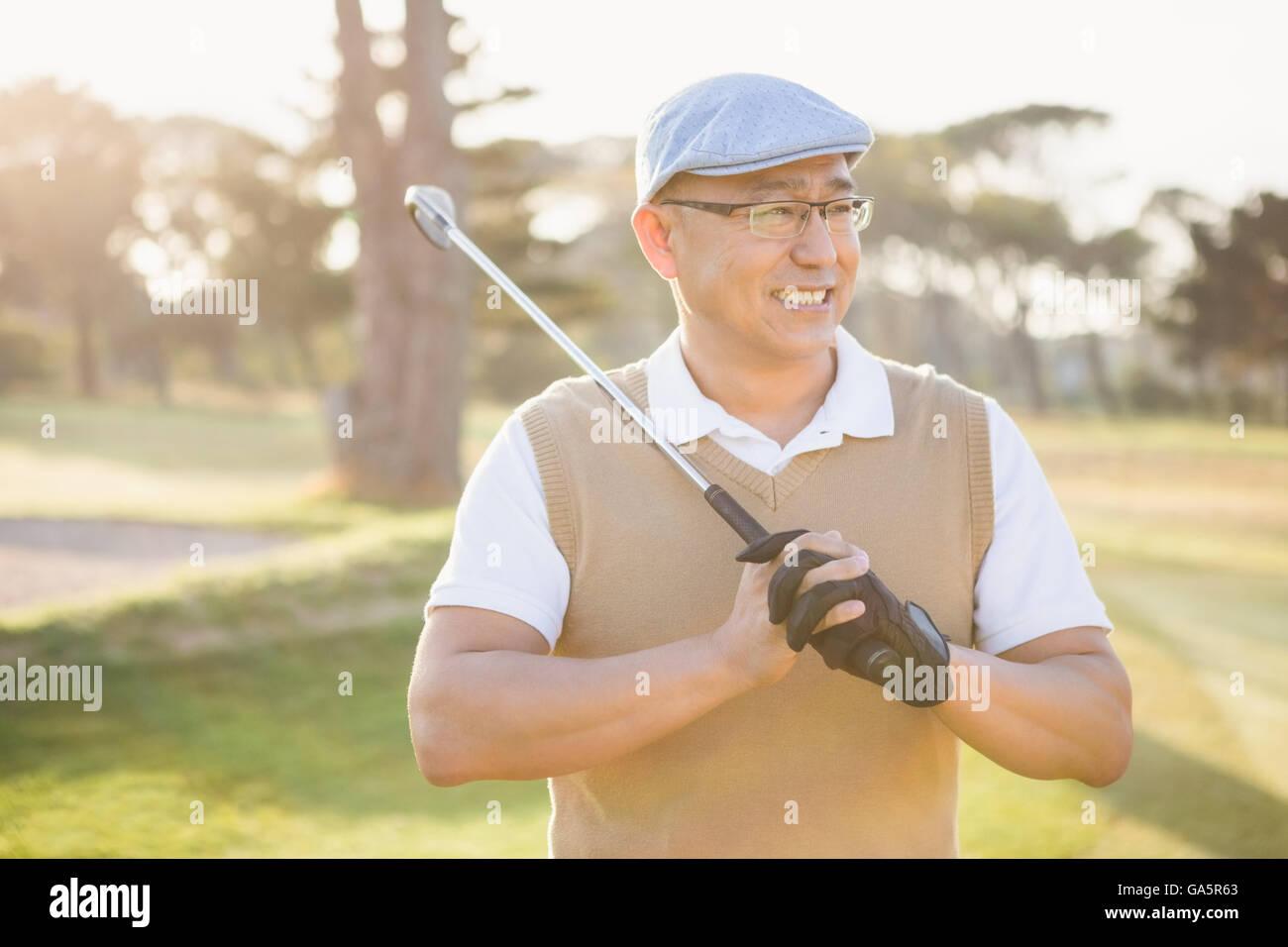 Sportsman looking away with his golf club Stock Photo - Alamy