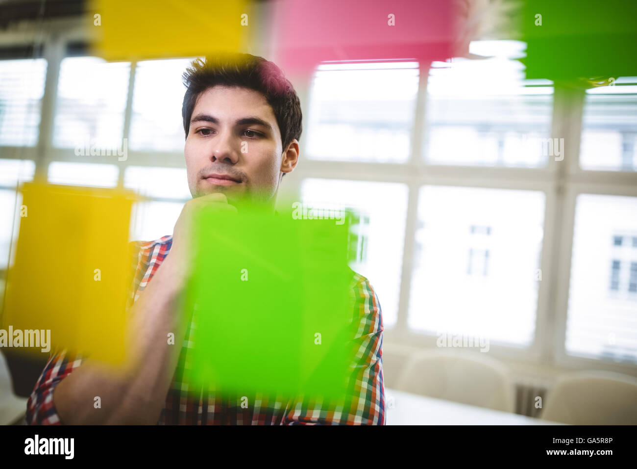 Businessman thinking while looking at sticky notes Stock Photo - Alamy