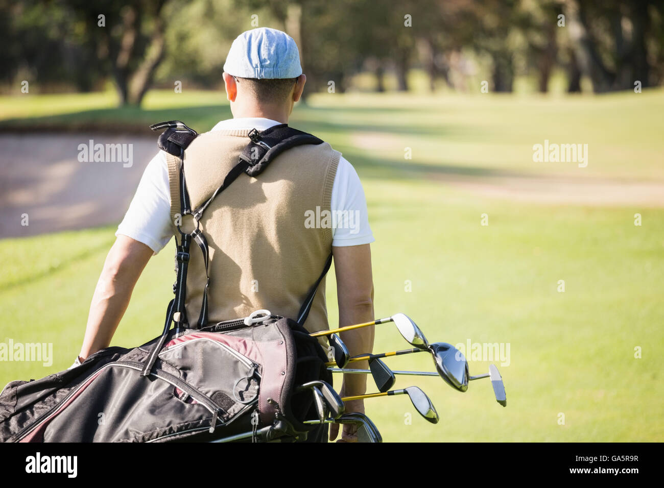 Rear view of sportsman holding a golf bag Stock Photo - Alamy