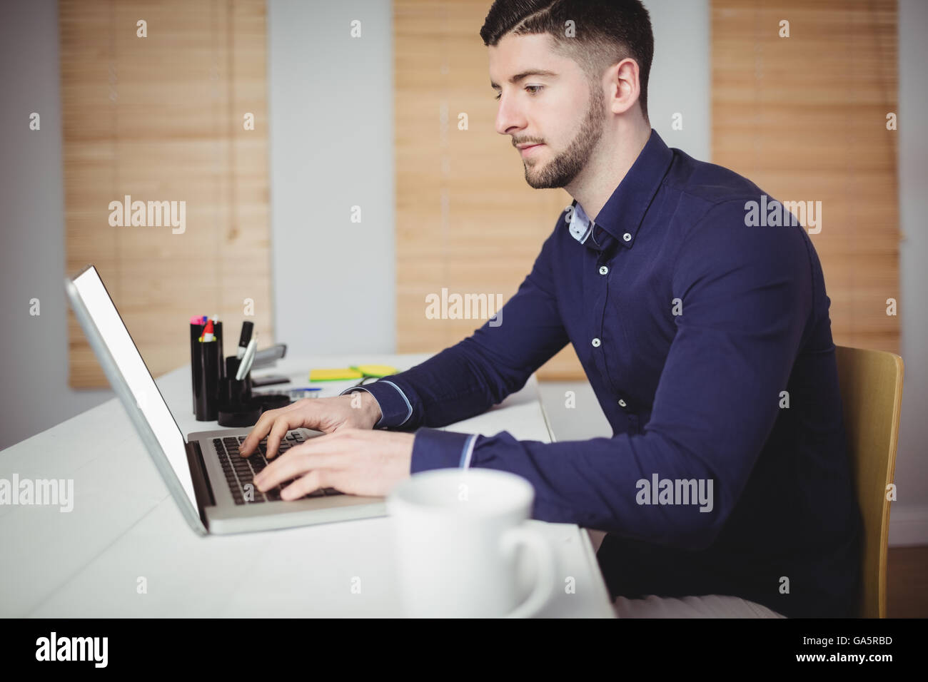 Man using laptop in office Stock Photo - Alamy