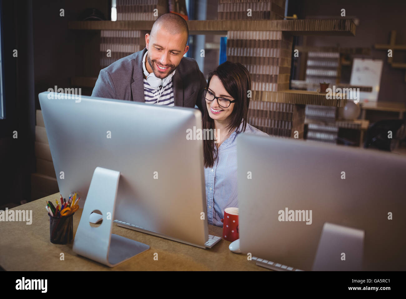 Business people smiling while looking at computer Stock Photo - Alamy