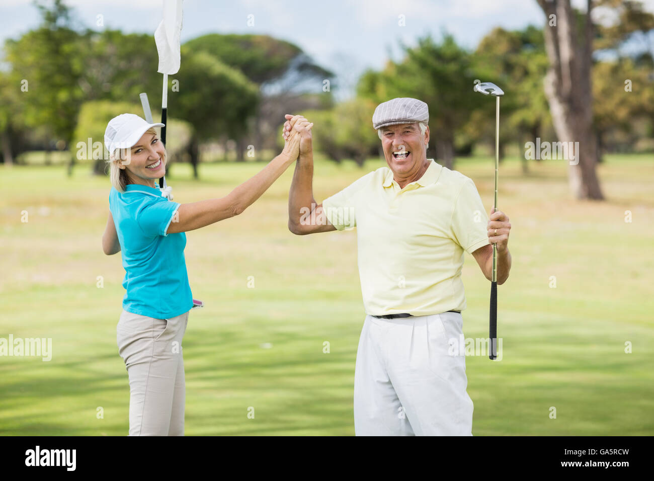 Portrait of golfer couple giving high five Stock Photo - Alamy