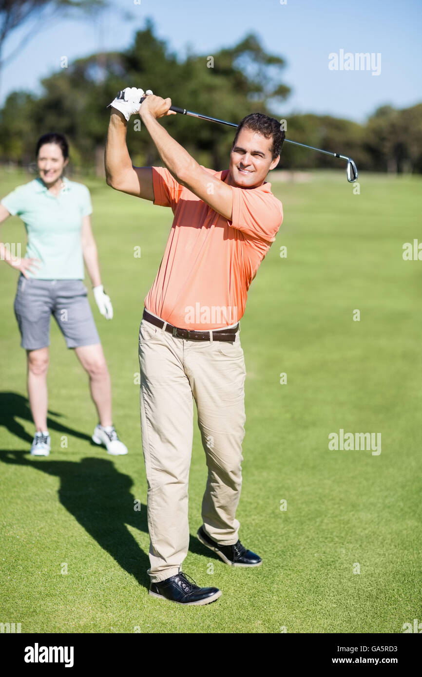Cheerful golfer taking shot Stock Photo - Alamy